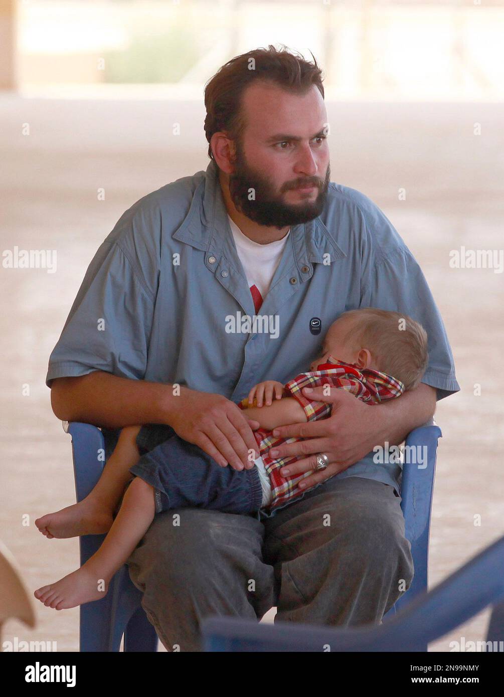 A Syrian refugee sits in front of his tent as he arrived at the border ...