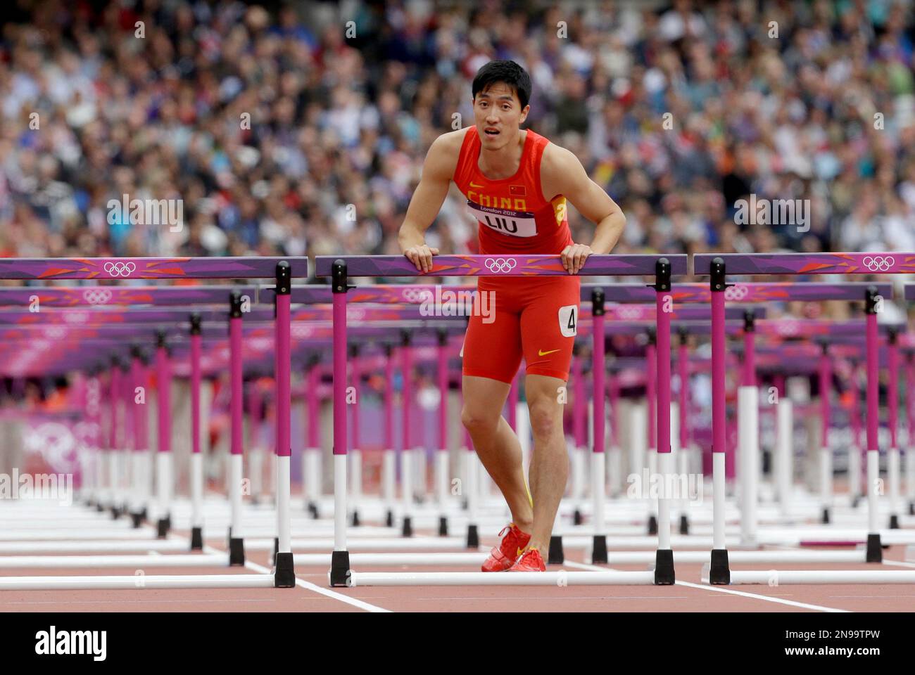 China's Liu Xiang rests on a hurdle after falling in a men's 110-meter ...