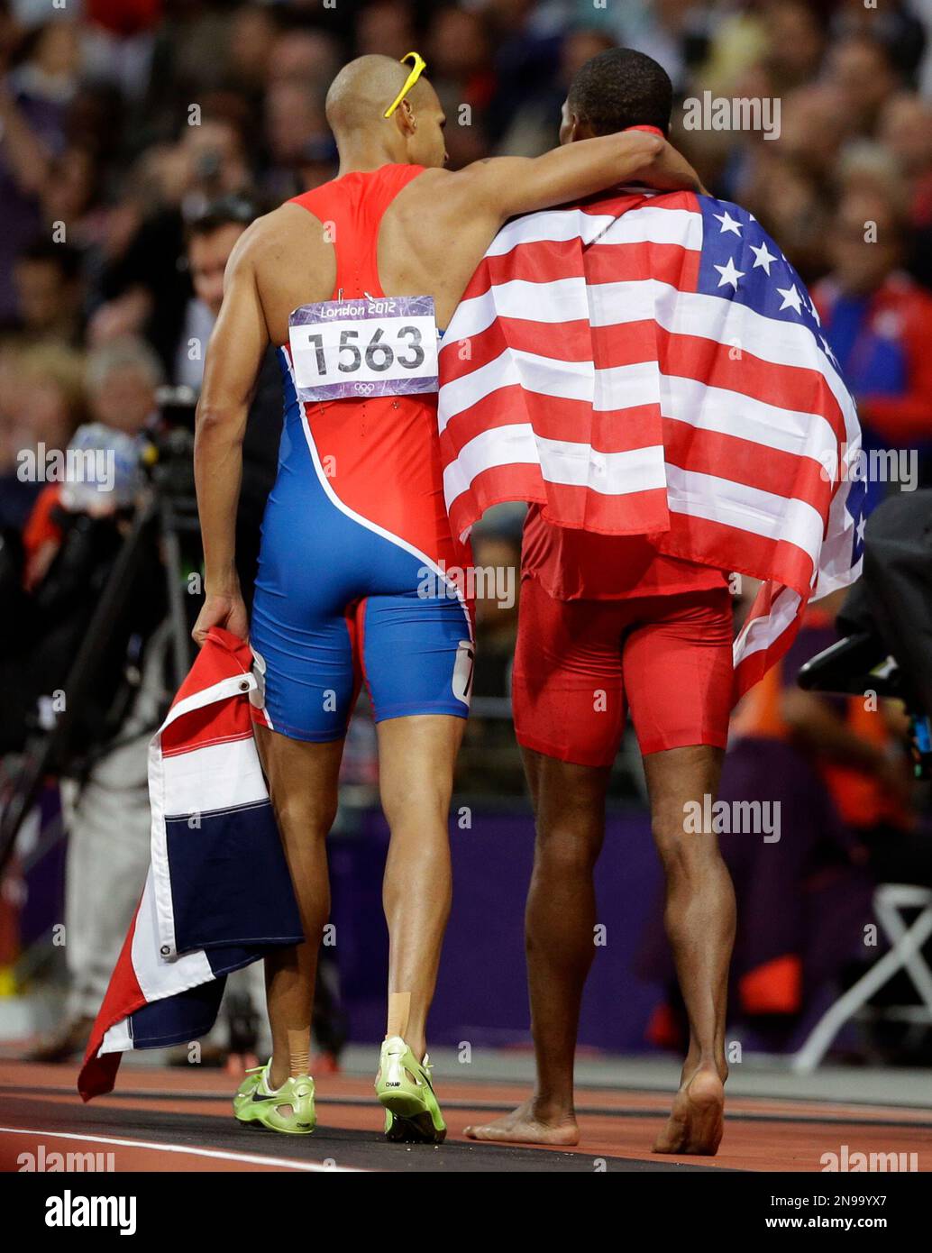 Dominican Republic's gold medalist Felix Sanchez, left, walks with ...