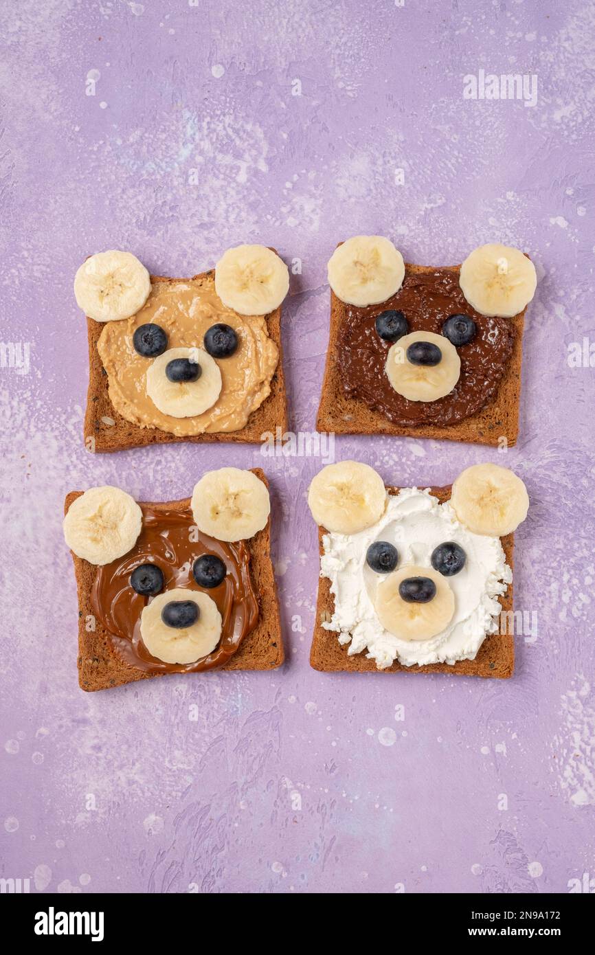 Breakfast toasts with nut butter and banana with cute funny bear face ...