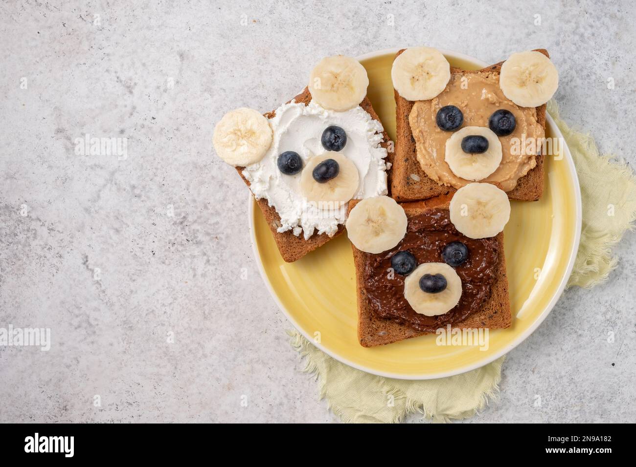 Breakfast toasts with nut butter and banana with cute funny bear face ...