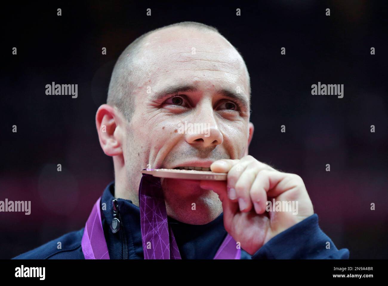 Italy's Matteo Morandi bites the bronze medal for his performance on ...