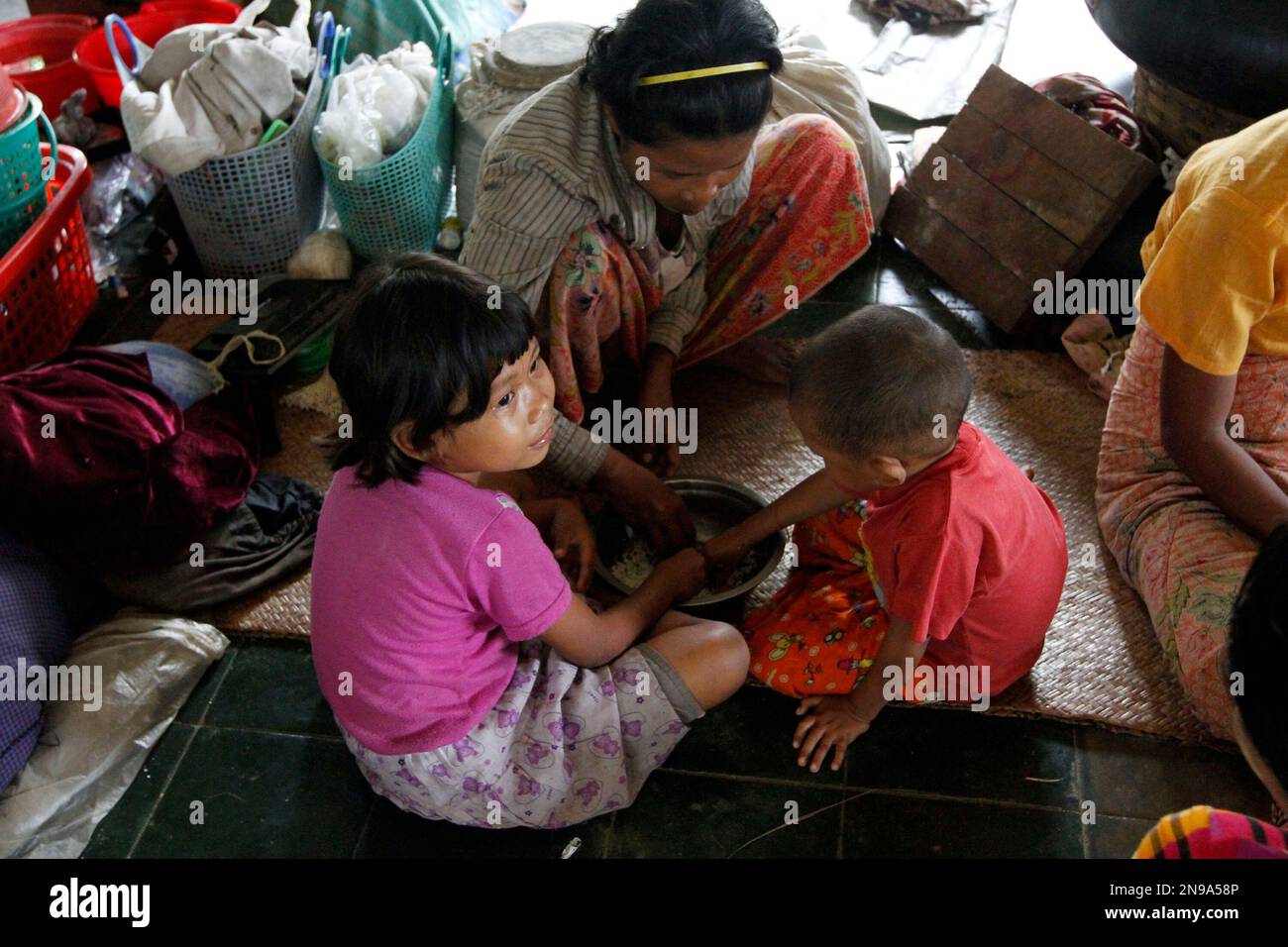 Flood victims eat distributed food at a monastery after the overflowing ...