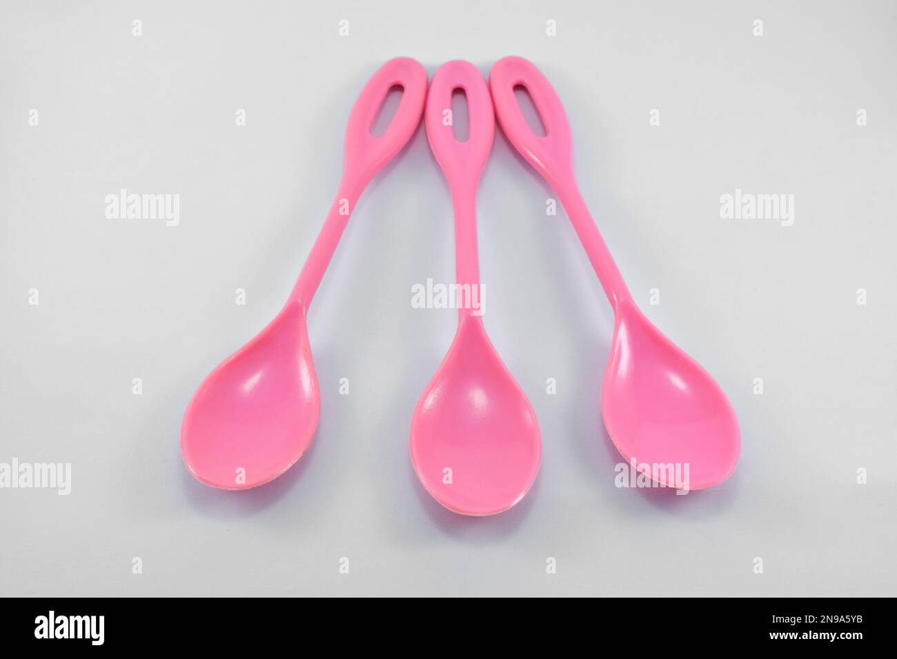 small pink plastic spoon isolated on white background Stock Photo - Alamy