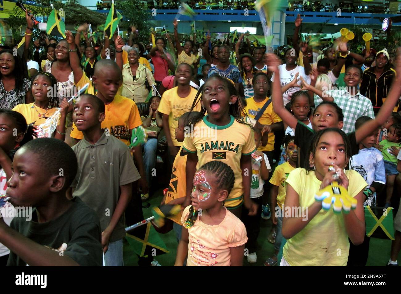 People cheer as they watch Olympic sprinters Usain Bolt and Yohan Blake ...