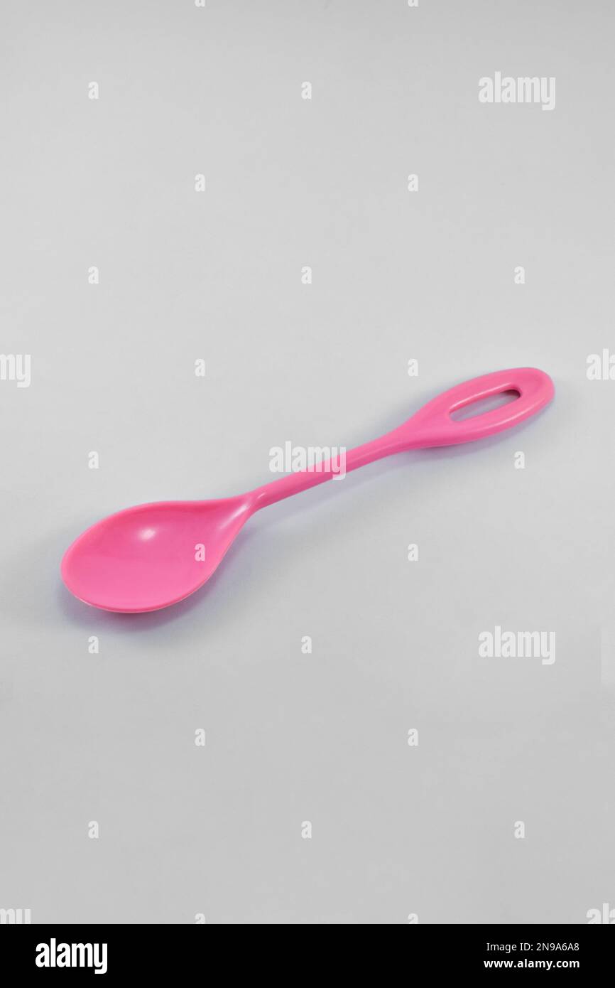 small pink plastic spoon isolated on white background Stock Photo - Alamy