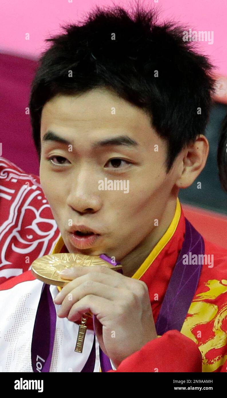 Chinese gymnast Zou Kai displays his gold medal for the artistic ...