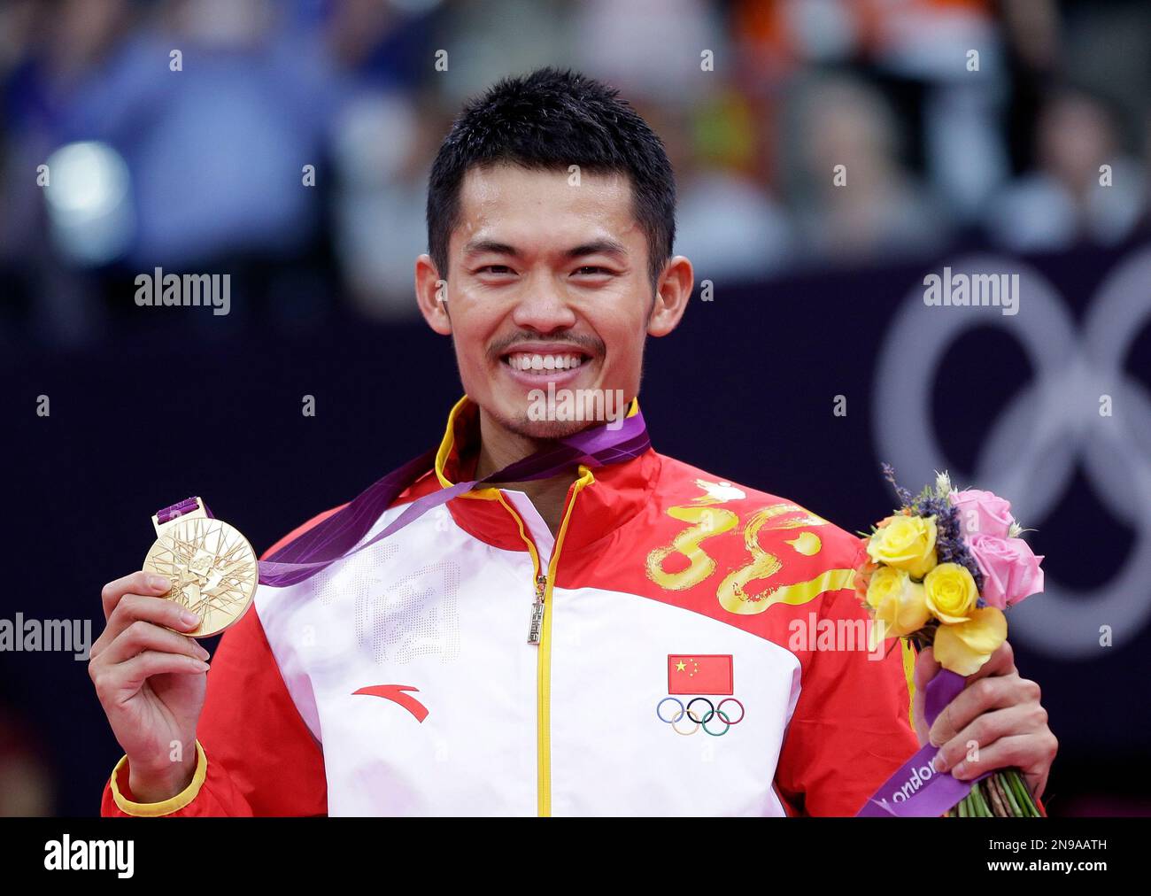 China's Lin Dan shows his gold medal after winning the men's singles ...