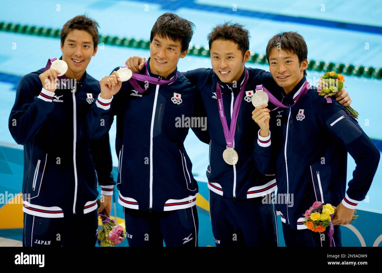 Japan's men's 4 x 100-meter relay team pose with their silver medals at ...