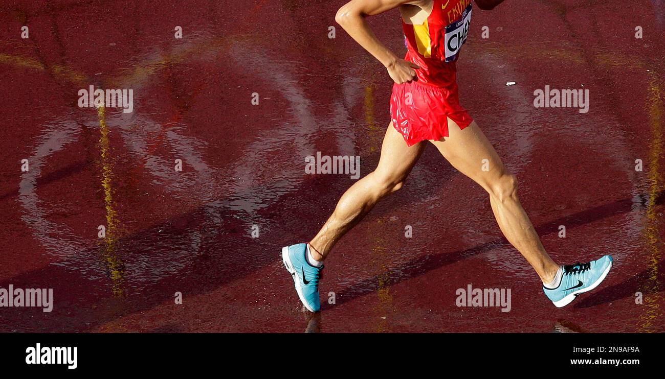 Gold medallist, Chen Ding, from China, walks past a mister as he ...
