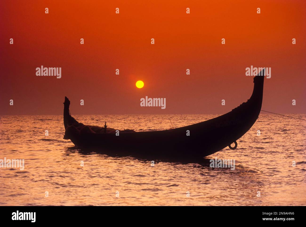 The Setting sun framed by the crescent shaped stern of a Catamaran in ...