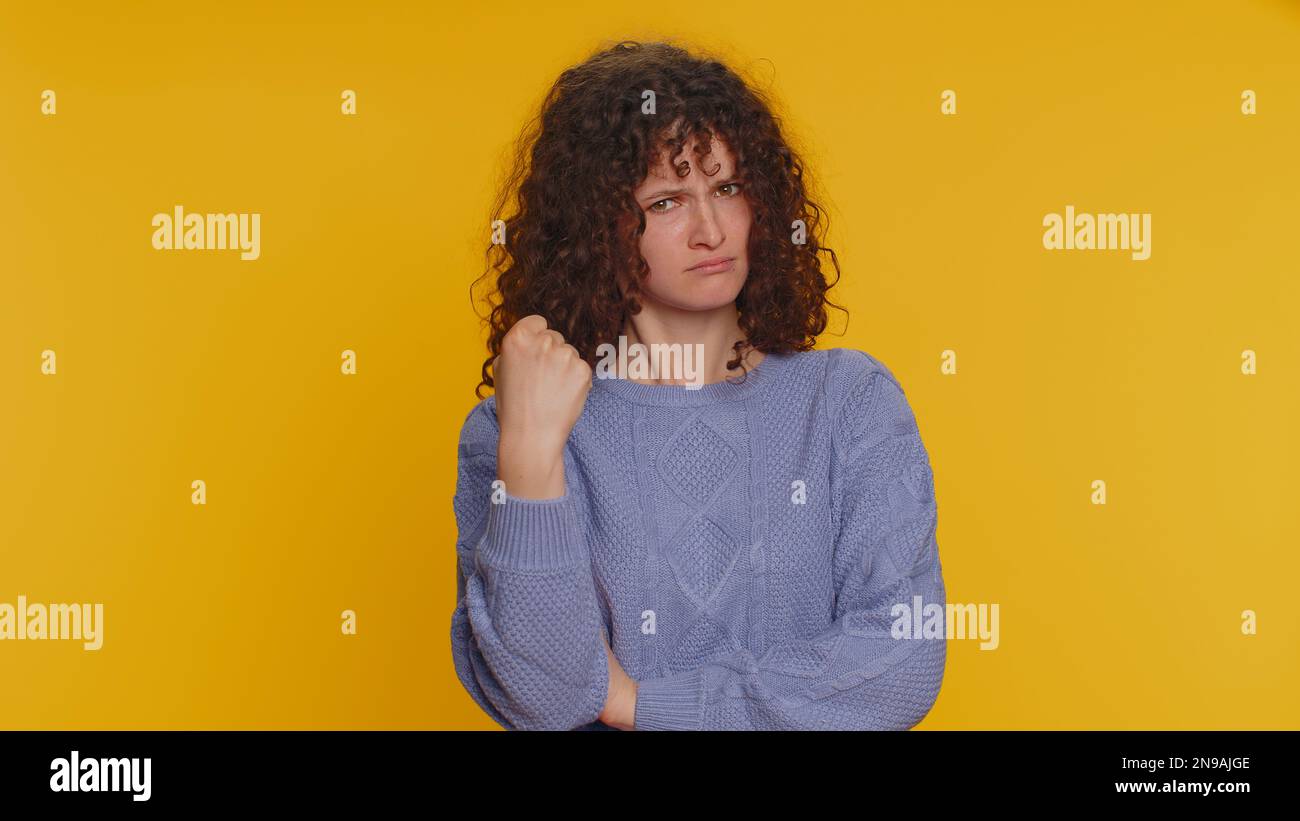 Aggressive angry curly haired woman trying to fight at camera, shaking ...