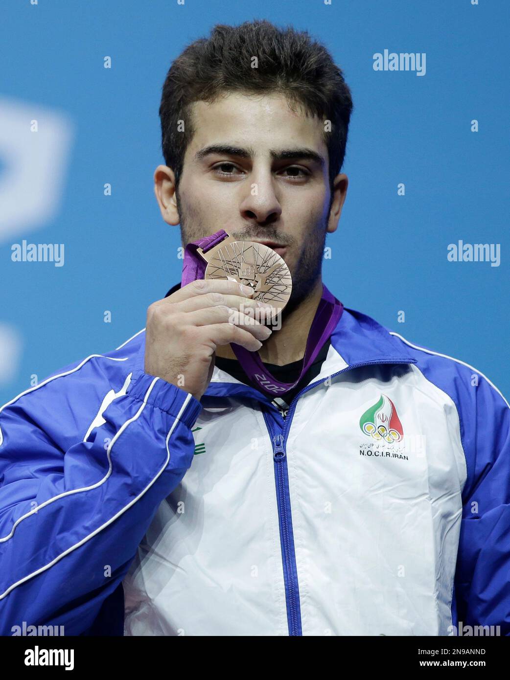 Bronze medalist Kianoush Rostami of Iran shows off his medal during a ...