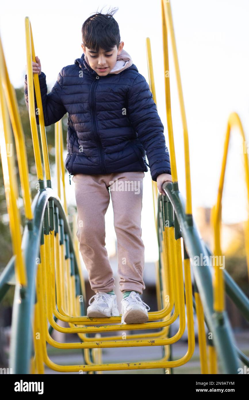 A vertical shot of a young boy playing on a metal playground Stock ...