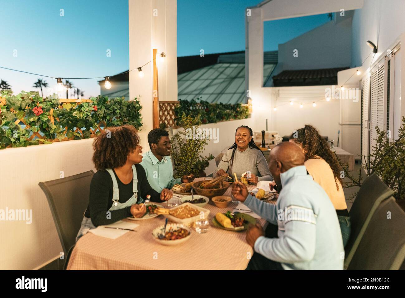 Happy African family dining together on house patio Stock Photo - Alamy