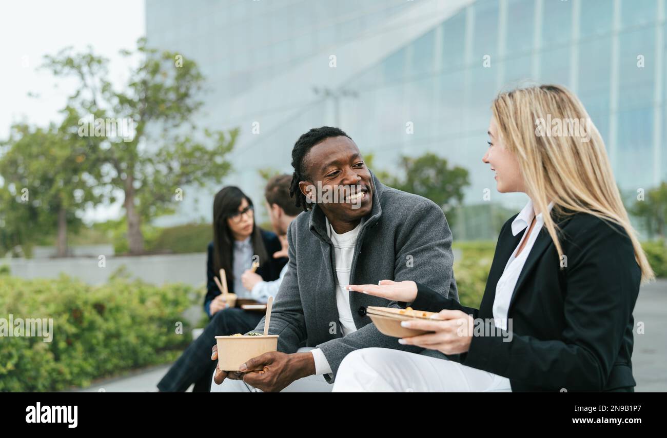 Happy business people having a lunch break outside office Stock Photo ...