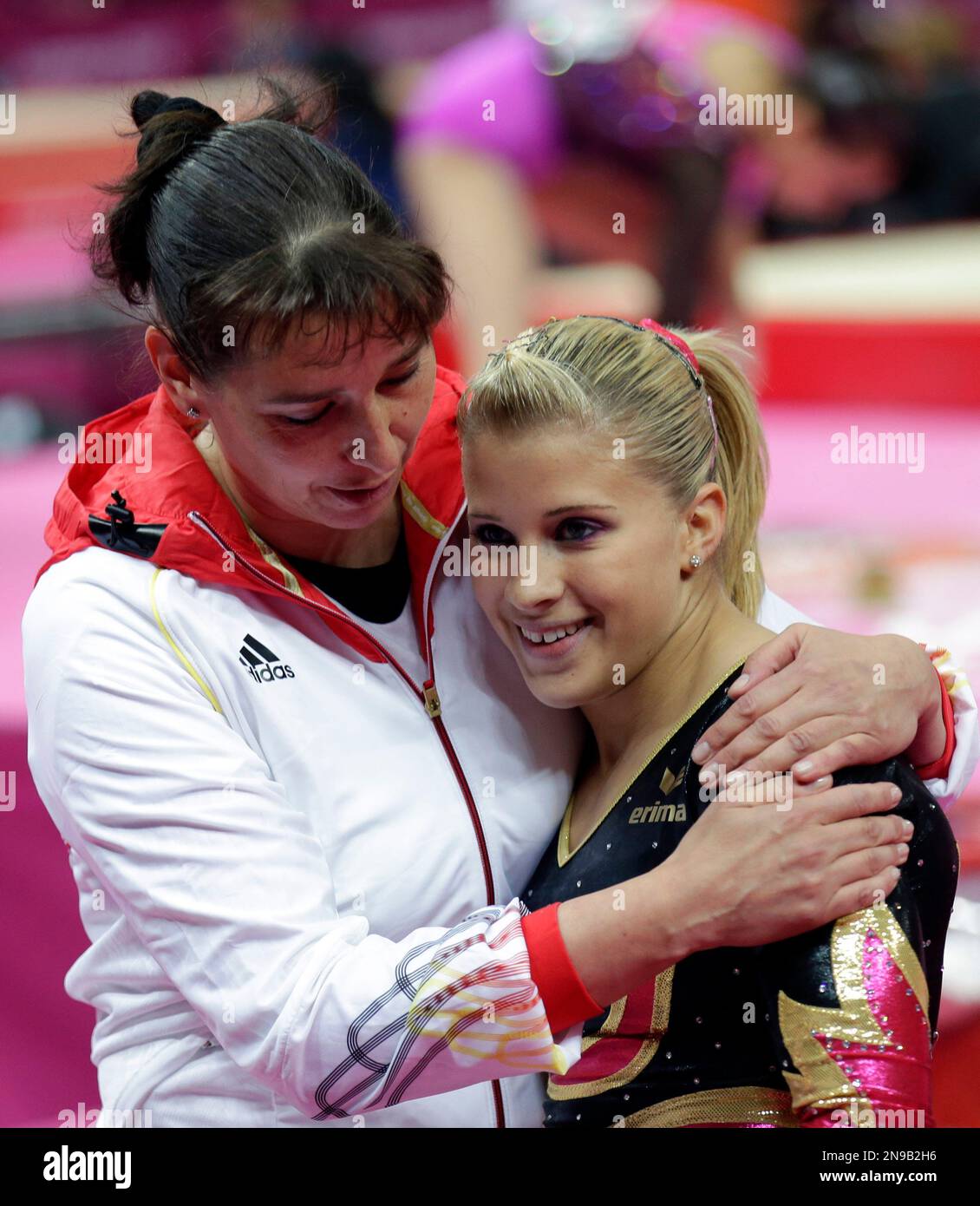 German gymnast Elisabeth Seitz is hugged by her coach after her beam ...