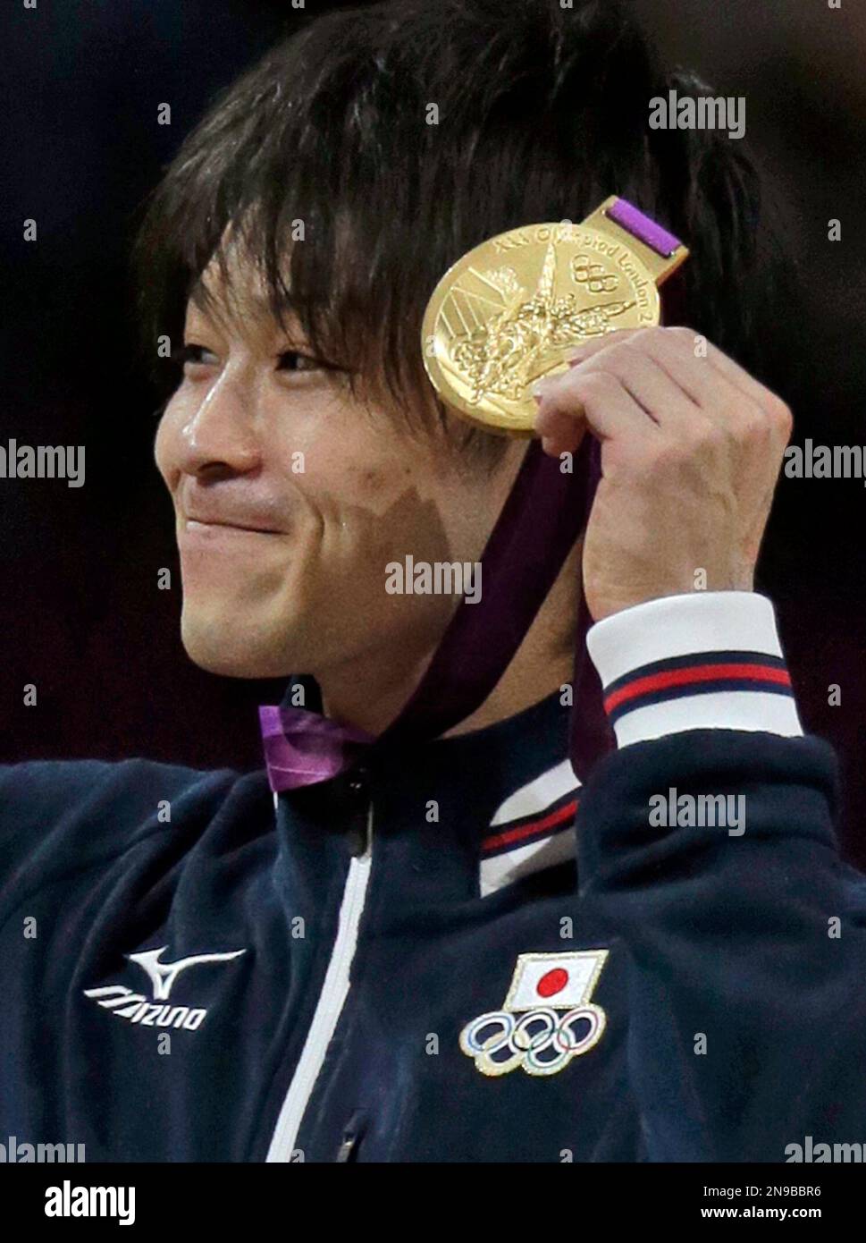 Japanese gymnast Kohei Uchimura displays his gold medal during the medal ceremony of the ...