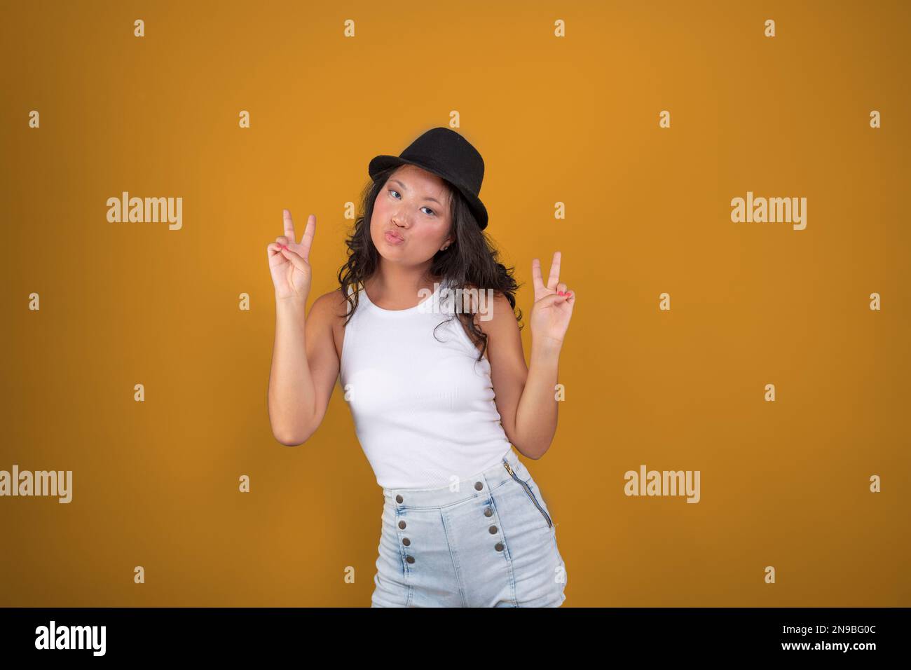 cute young asian girl, with hat making cute face isolated from the ...