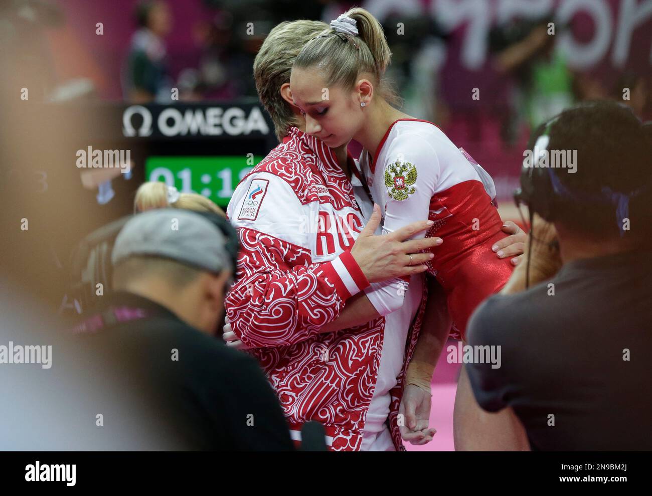 Russian gymnast Victoria Komova is consoled by a team official after a ...