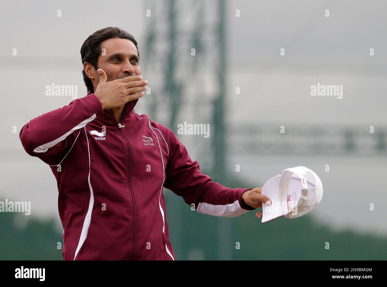 Qatar's Nasser Al-Attiya blows a kiss from the medals podium, as he ...