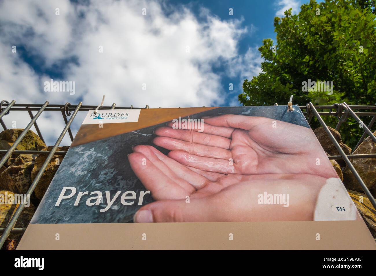 Lourdes, France - August 28, 2021: Open hands touching the holy water ...