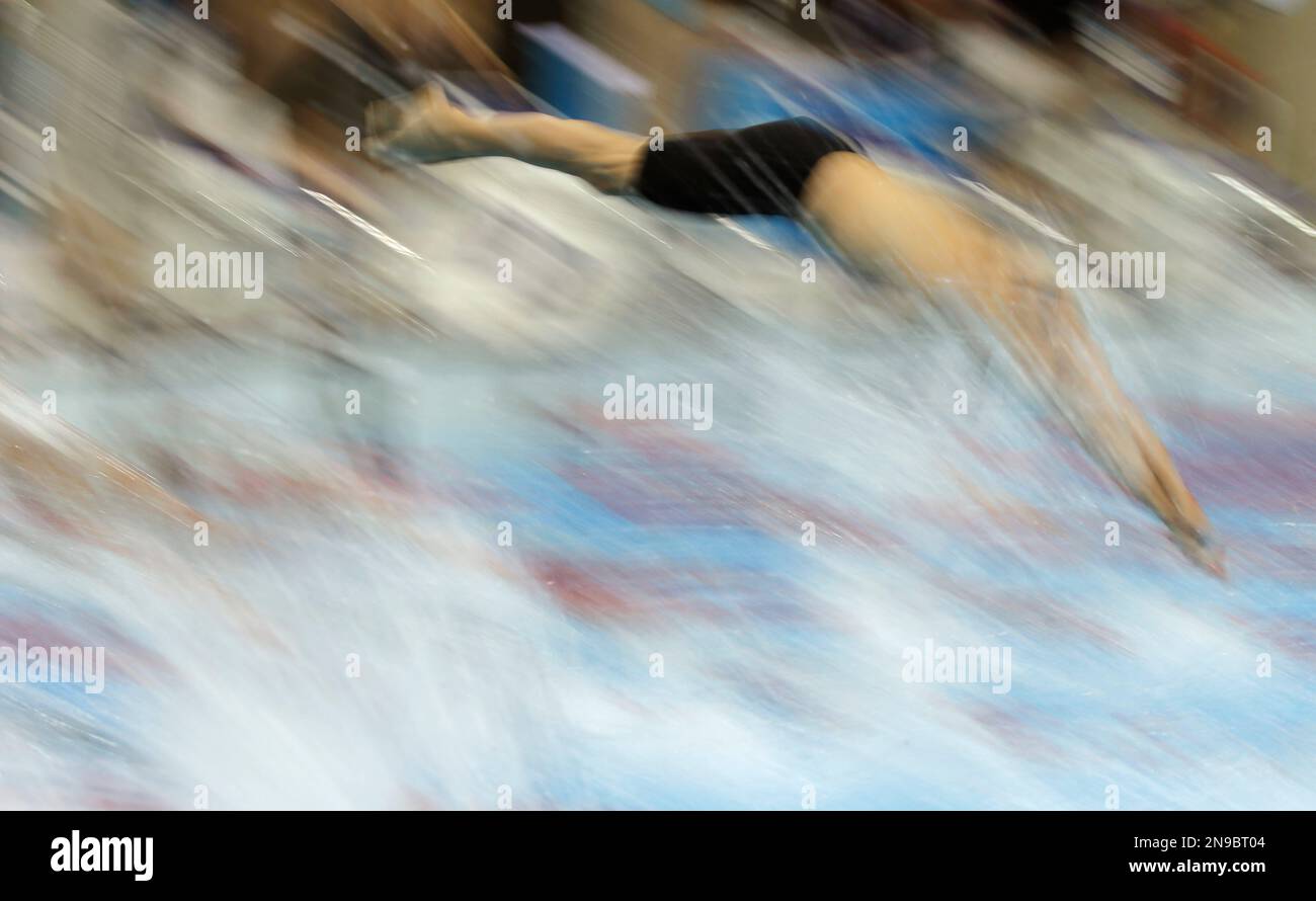 A swimmer dives during a men's 4x200-meter freestyle relay swimming ...