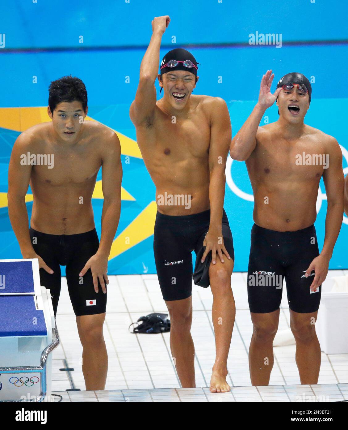 Members of Japan's men's relay team cheer on a teammate in a men's ...