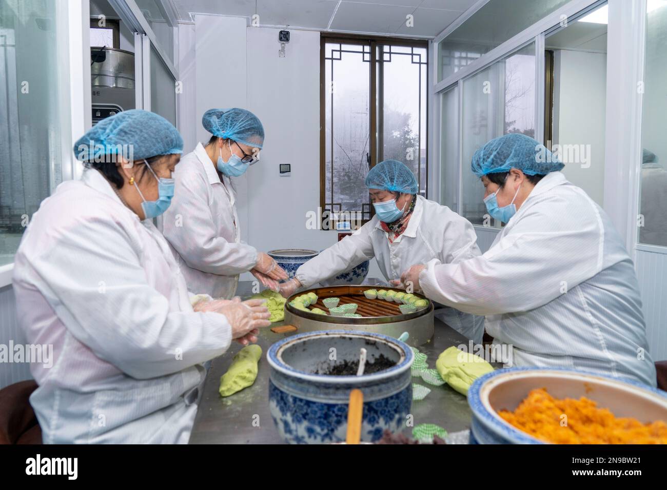 KUNSHAN, CHINA - FEBRUARY 11, 2023 - An employee of a pastry shop makes green Tuanzi, a ...