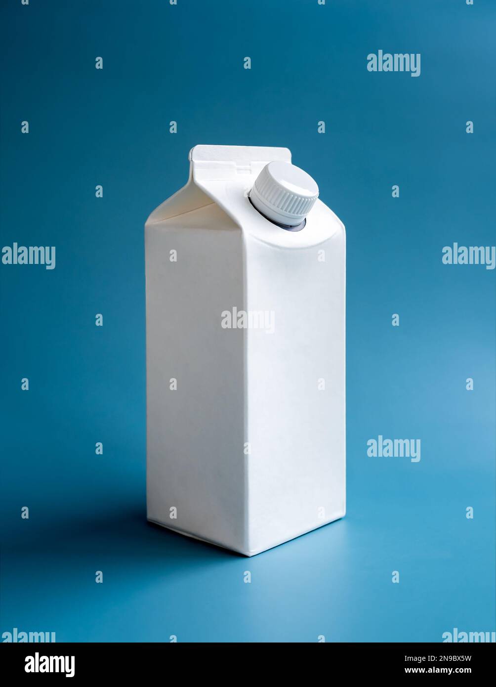 Mockup white milk box 1 liter with screw cap standing isolated on blue ...