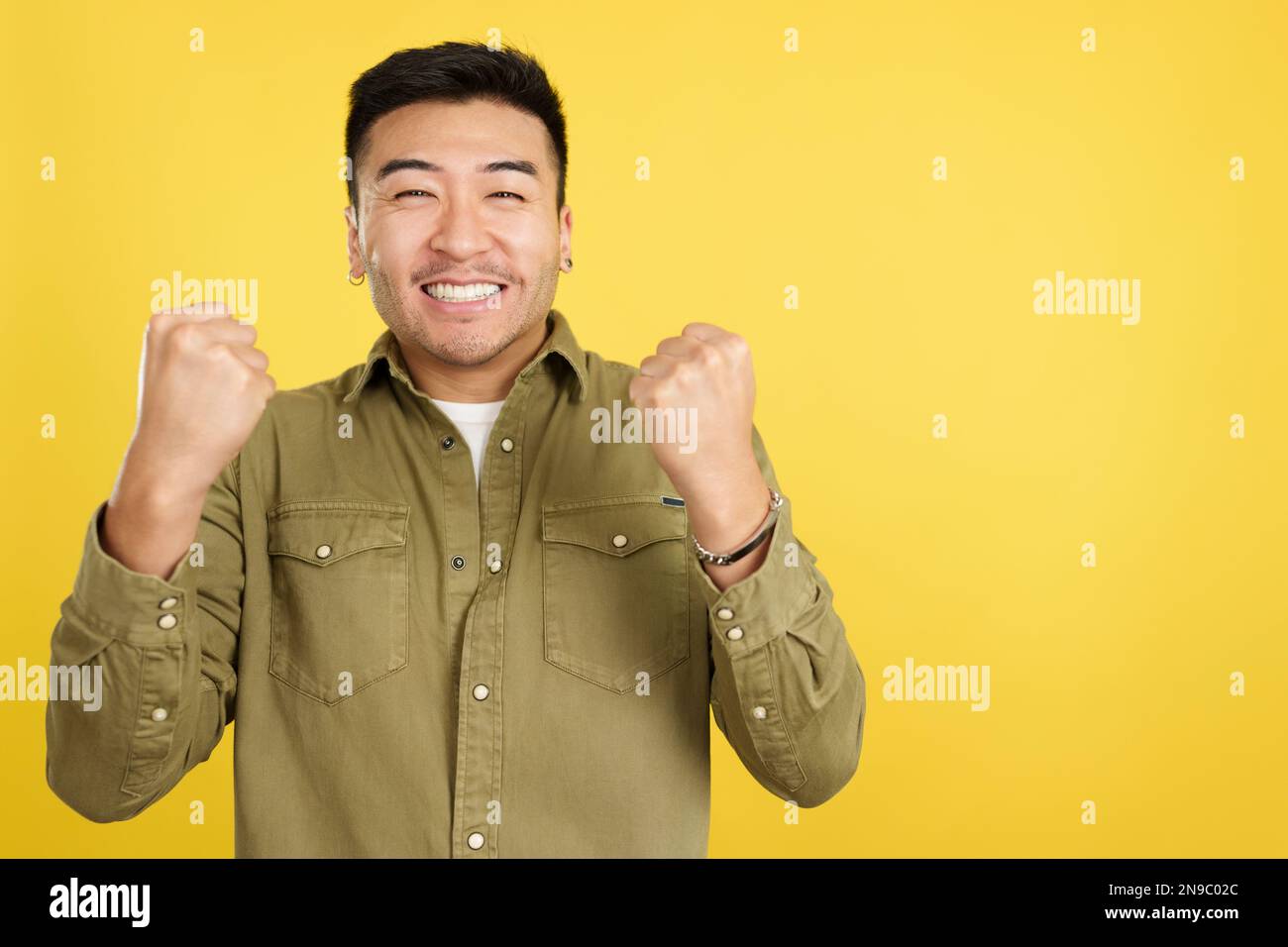 Happy chinese man celebrating while raising fists Stock Photo - Alamy