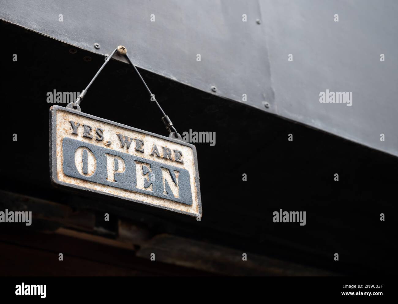 Text, Yes, we're open, vintage rusty signage hanging on the screw on ...