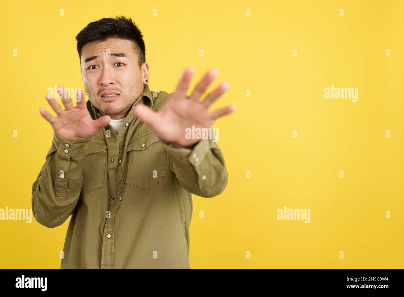 Chinese man gesturing with the hands in fear Stock Photo - Alamy