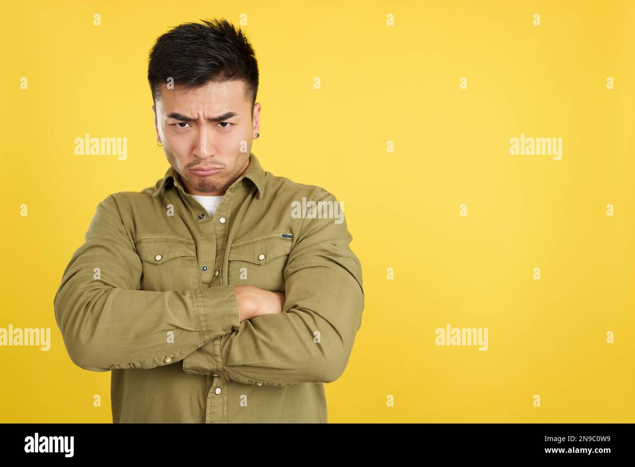 Chinese man crossing the arms with an angry expression Stock Photo - Alamy