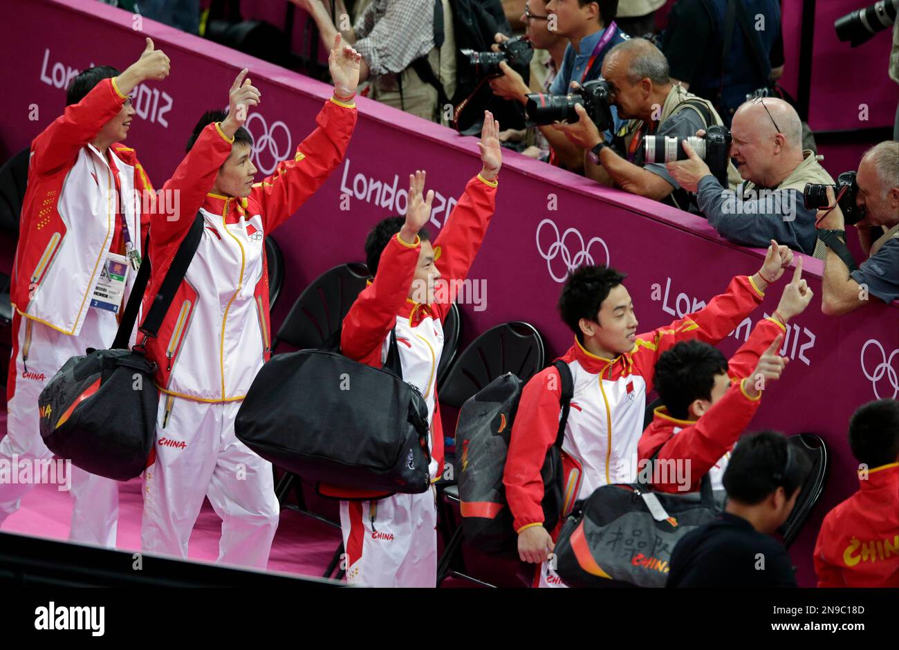 Chinese gymnasts wave as they walk after winning the gold during the ...