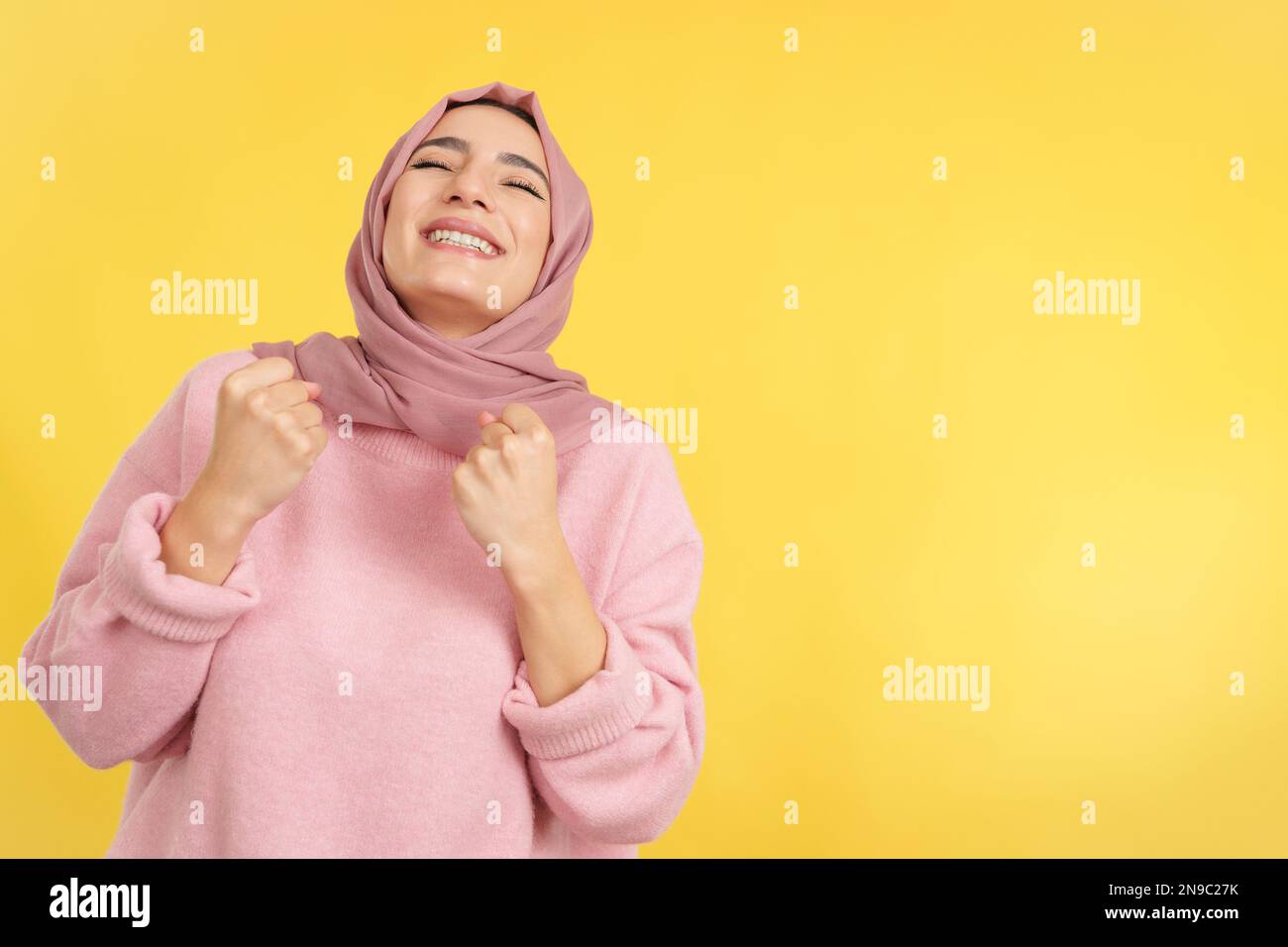 Happy muslim woman celebrating while raising fists Stock Photo - Alamy