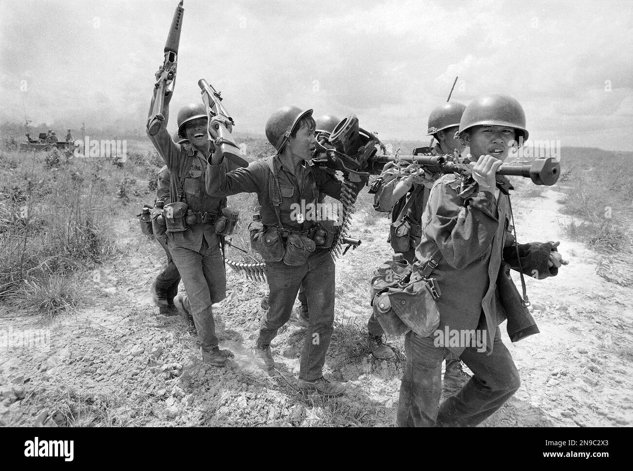 Jubilant South Vietnamese troops carry a North Vietnamese heavy machine ...