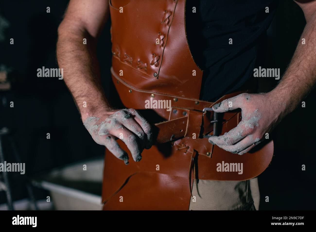 Man sculptor dress put on leather apron with clay in hands. Statue ...