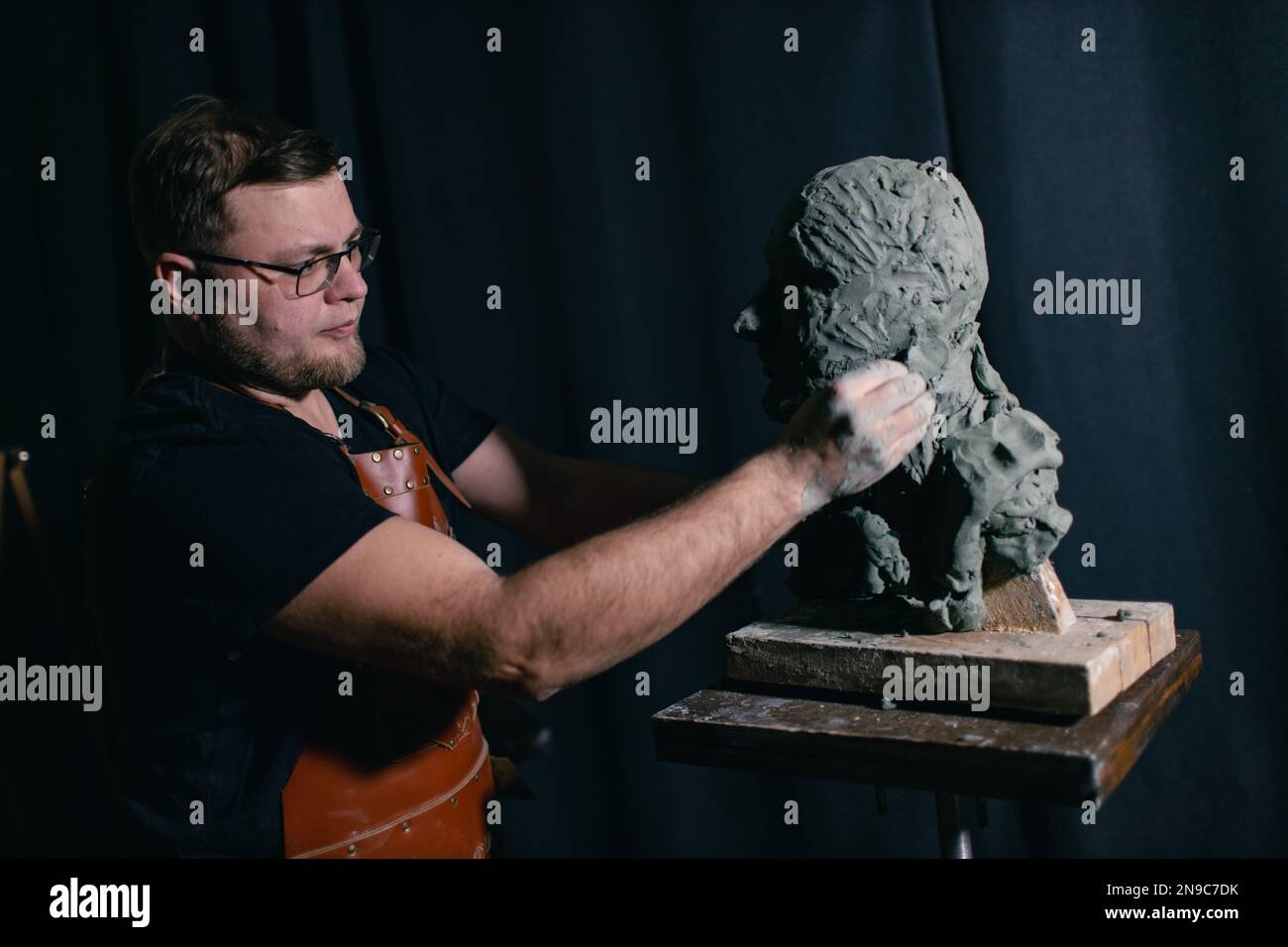 Man sculptor creates sculpt bust clay human woman sculpture. Statue ...