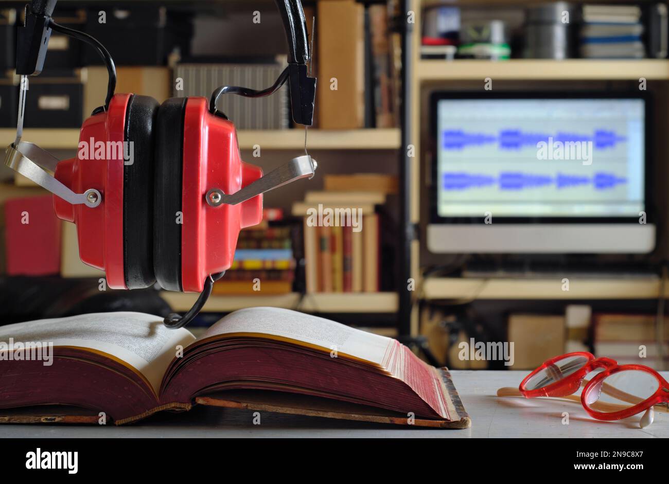 audio book concept with open book and vintage red headphones,blurred ...
