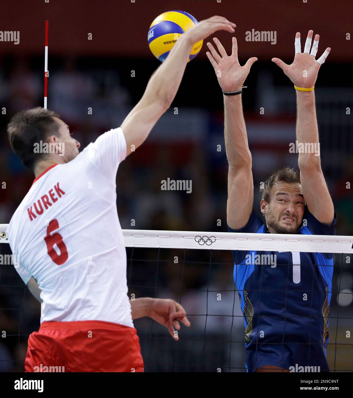 Poland's Bartosz Kurek, left, spikes the ball past Italy's Michal Lasko ...