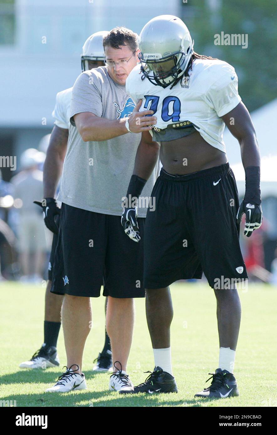 Detroit Lions defensive line coach Kris Kocurek, left, shows a position ...