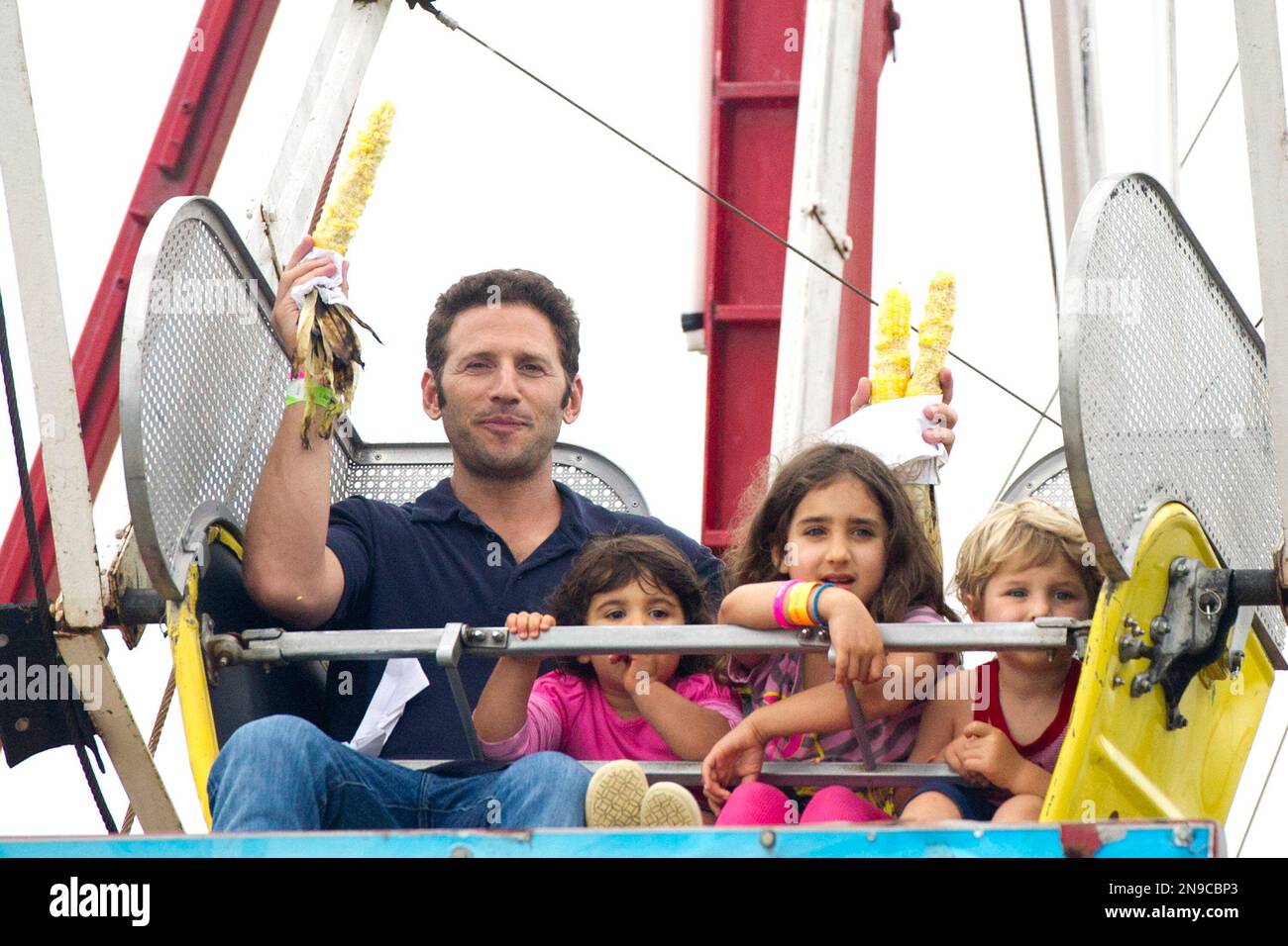 Mark Feuerstein rides a ferris wheel with his children, from left to ...