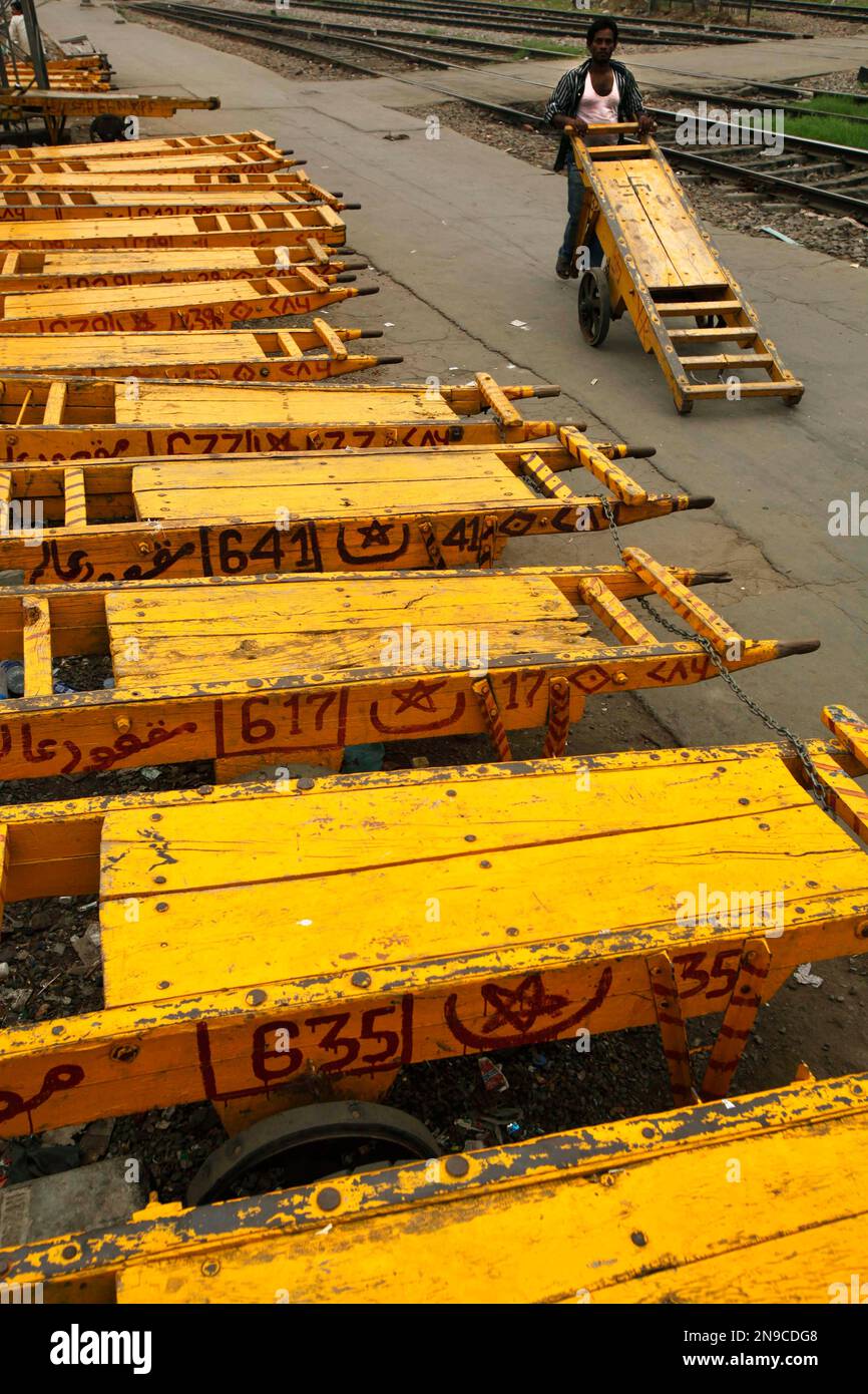 An Indian railway worker pushes a push cart at the New Delhi railway ...