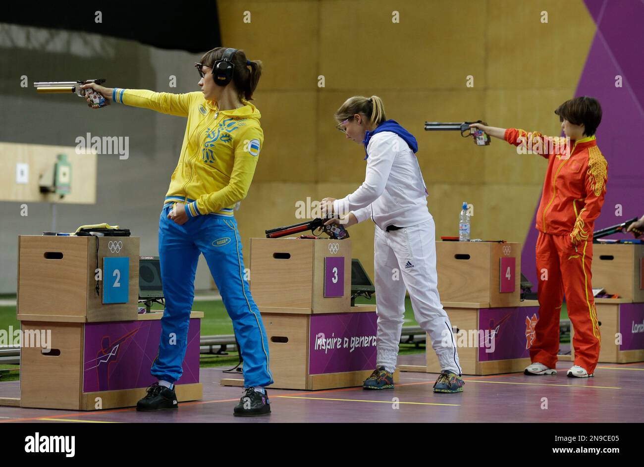 France's Celine Goberville, center, adjusts her gun as Ukraine's Olena ...