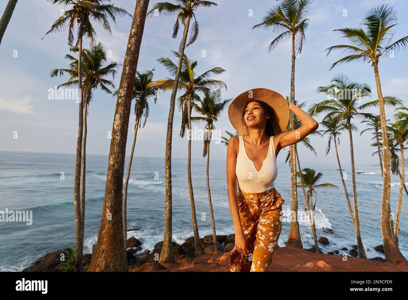 Young african female model posing in colorful clothes at tropical ...