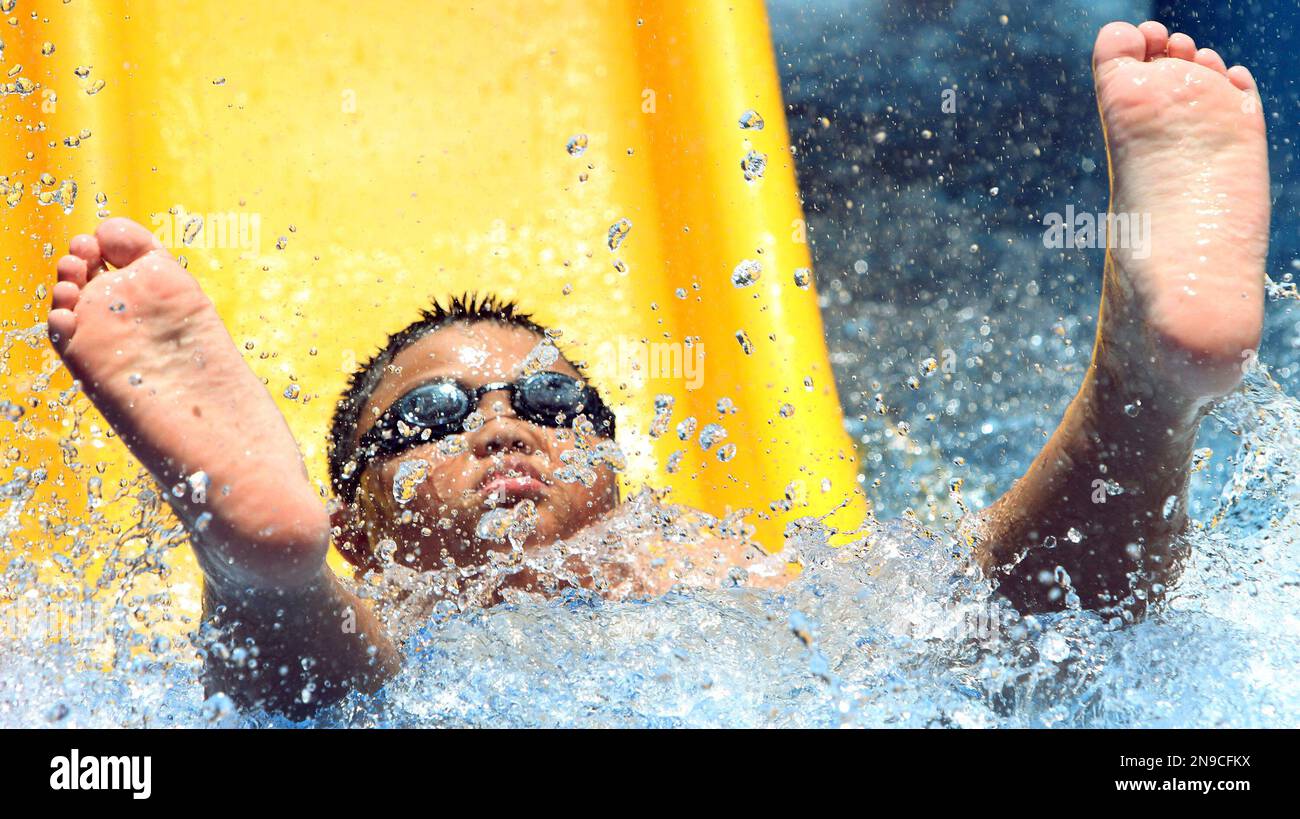 A Taiwanese boy slides into water at Taipei Water Museum in Taipei ...