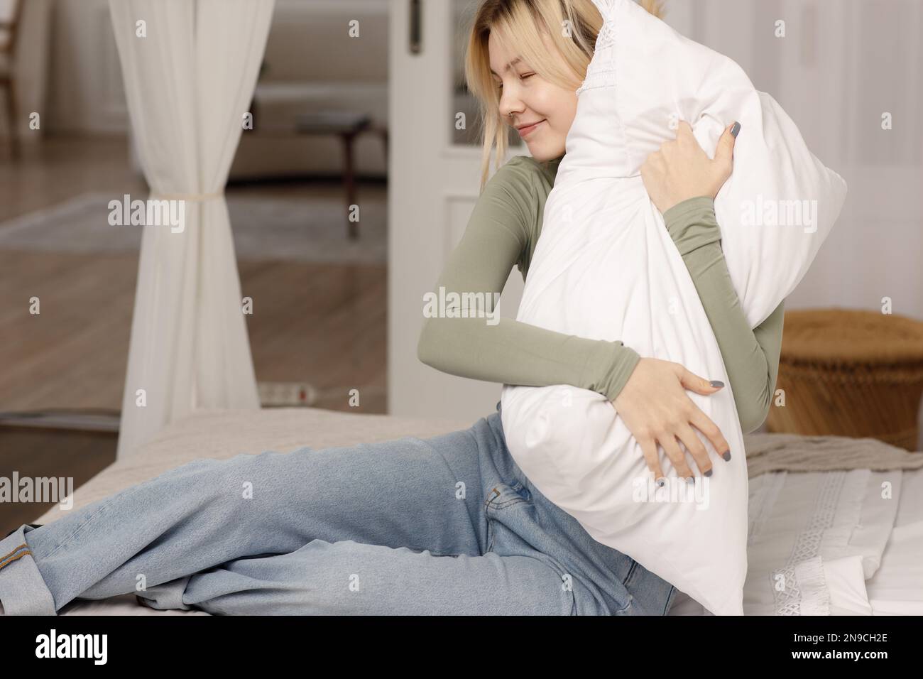 Relaxing young woman hugs pillow in bed. Healthy sleep Stock Photo - Alamy