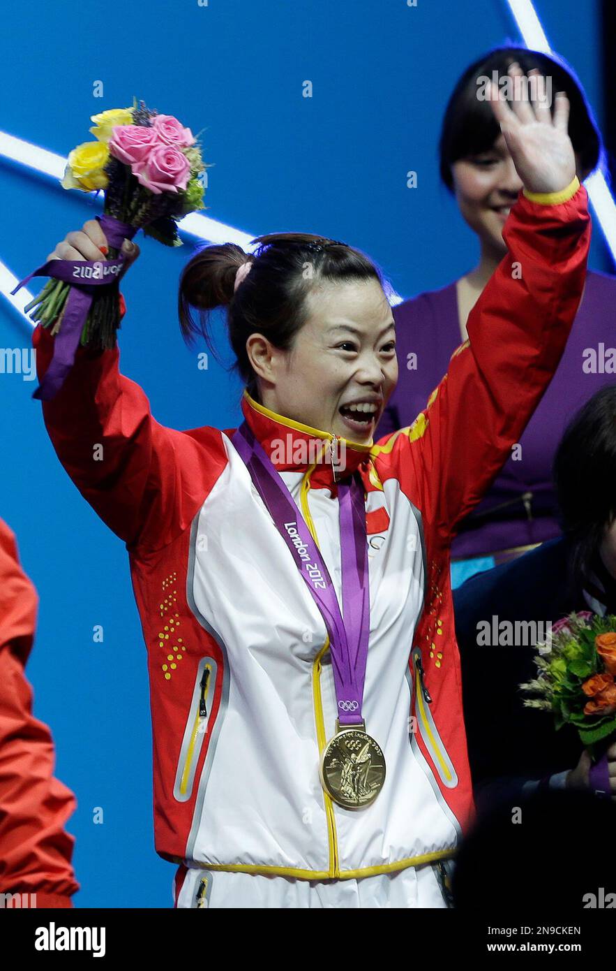 China's Wang Mingjuan holds flowers during a medals ceremony after ...