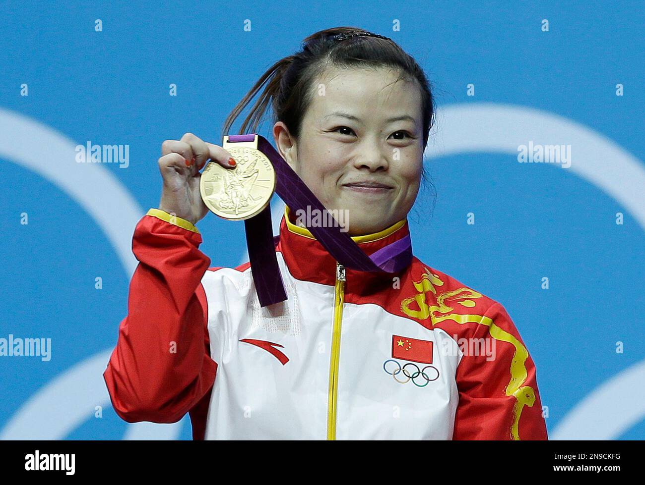 China's Wang Mingjuan holds up her medal during a medals ceremony after ...